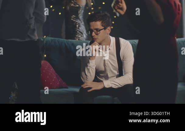 Sad and unhappy guy feeling lonely at celebrate at home, sitting on ...