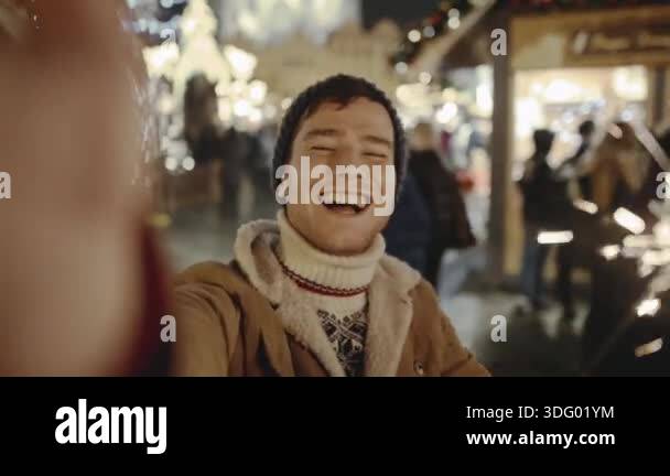 Funny young man smiling and making selfie with his smartphone at ...