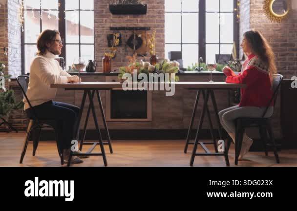 Two people sitting on different sides of table at christmas eve and ...
