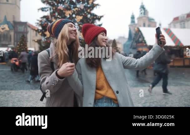 Two blogger girls standing on xsmas square in Prague taking selfie ...