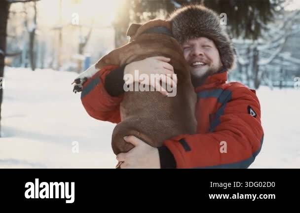 Happy bearded man hugging his bulldog at winter sunny day. Friendship ...