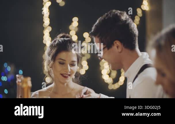 Close shot of portraits of young couple talking at table during holiday ...