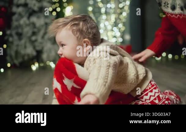 Baby took red hat in his mouth, crawls on his knees and enjoys the new ...