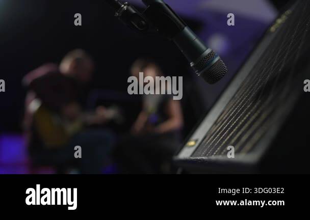 microphone stand and guitar amplifier in front of beautiful girl ...