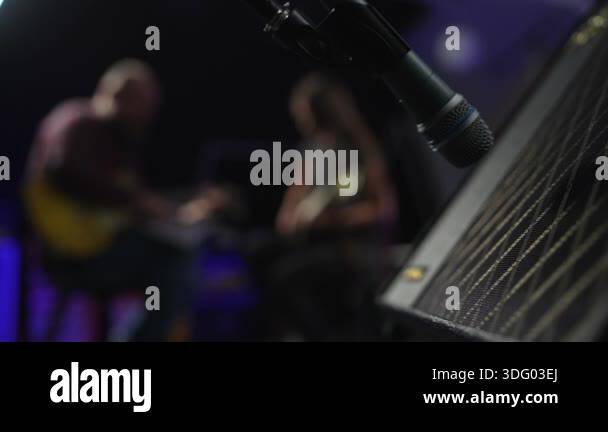 microphone stand and guitar amplifier in front of beautiful girl ...