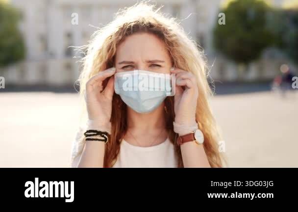 Happy Hispanic girl walking outdoor while taking off her protective ...