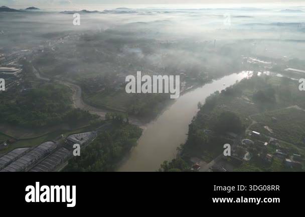 A river is shown in the distance with a foggy sky. The sky is hazy and ...