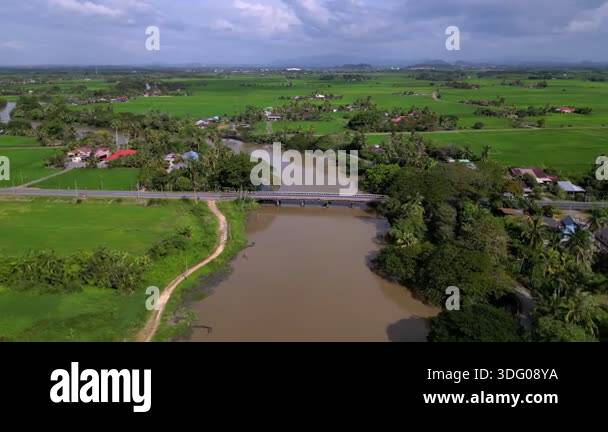 A river runs through a green field with a bridge over it. Aerial view ...