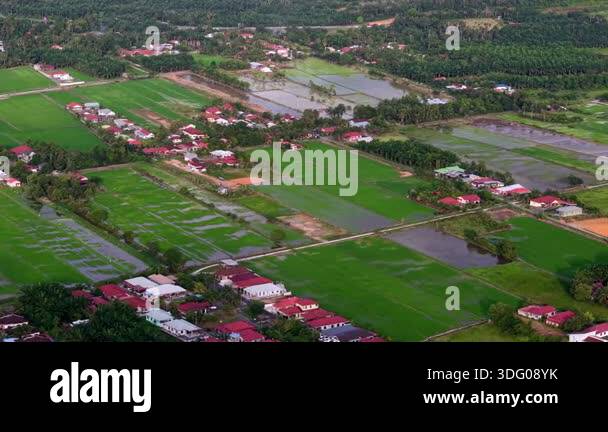 Rural area with houses and fields. The houses are red and the fields ...