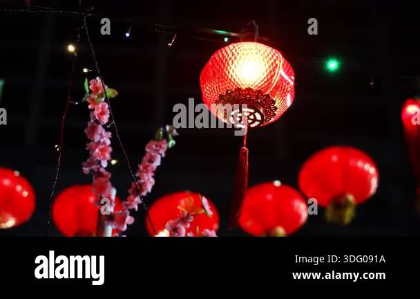 A red lantern hangs from a string. There are several other red lanterns ...