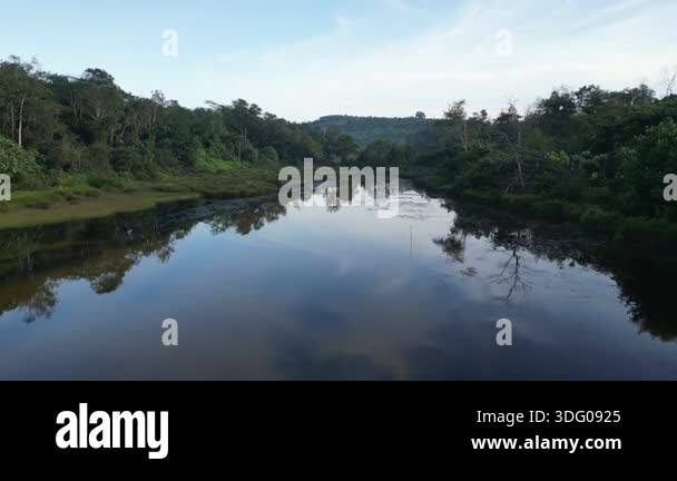 A river with a reflection of the sky on the water. The sky is blue and ...