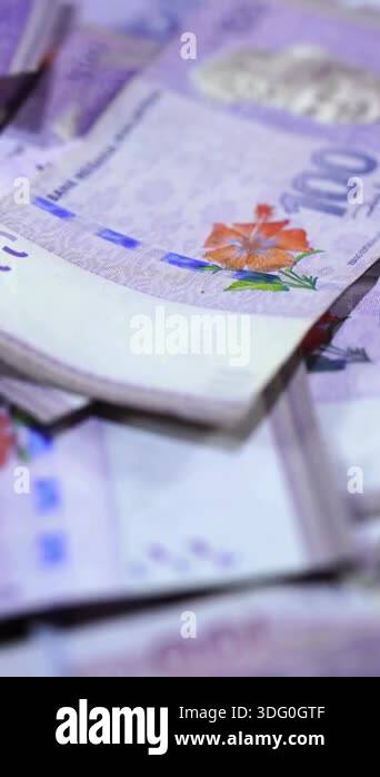Vertical close up of counting stack of one hundred malaysian ringgit ...