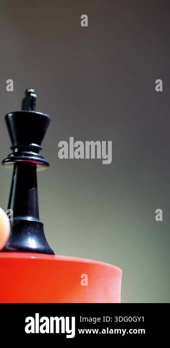 Close up of black chess king standing on red podium with white pawn ...