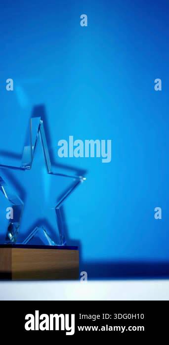 Crystal glass star shaped trophy on wooden base rotating against a ...