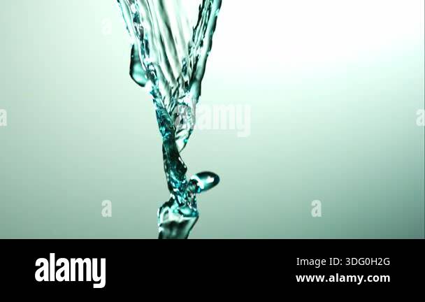 A single drop of water falls followed by a wide sheet of clear liquid ...