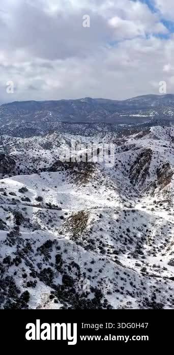 High aerial shot of a vast mountain range covered in a fresh blanket of ...