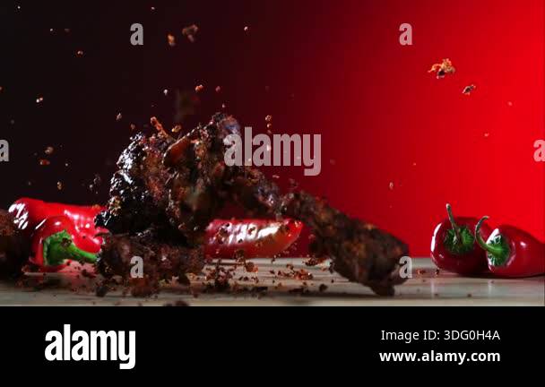Pieces of dark seasoned fried chicken fall through the air and bounce ...