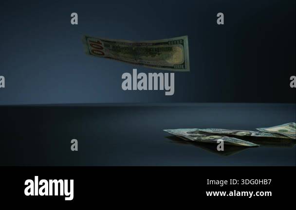 One hundred dollar bills fall through the air and land on a dark ...