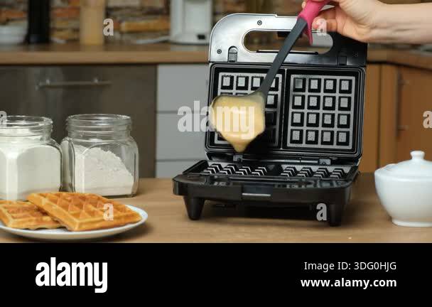 Pouring Fresh Waffle Batter with a Ladle into a Black Electric Waffle ...