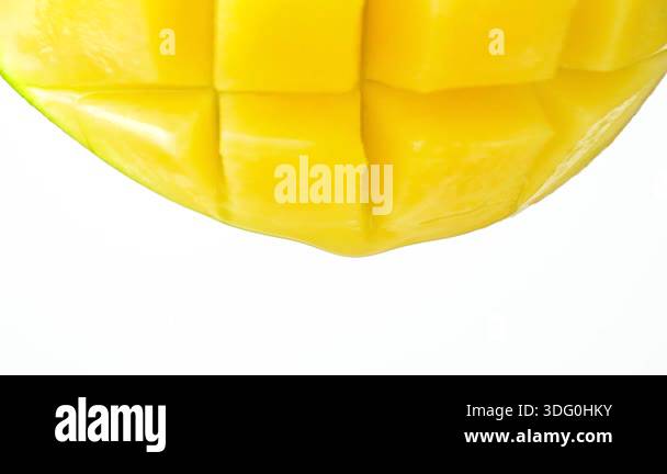 Mango juice slowly dripping from fresh fruit, white background, macro ...