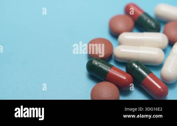 Pills with copy space on blue. Video of capsules and tablets arranged ...