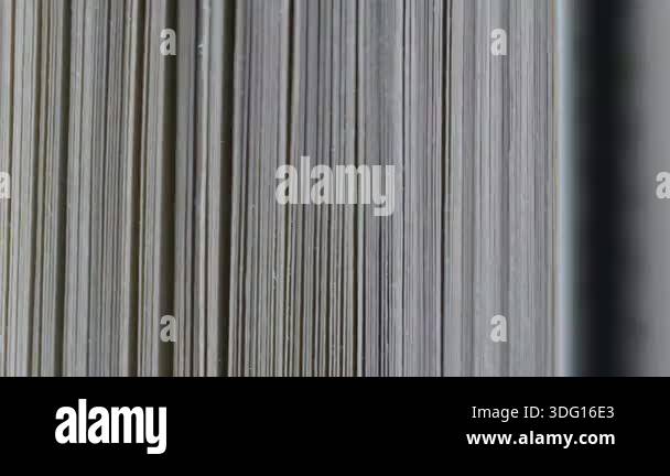 Detailed horizontal view of thick book pages flipping through the frame ...