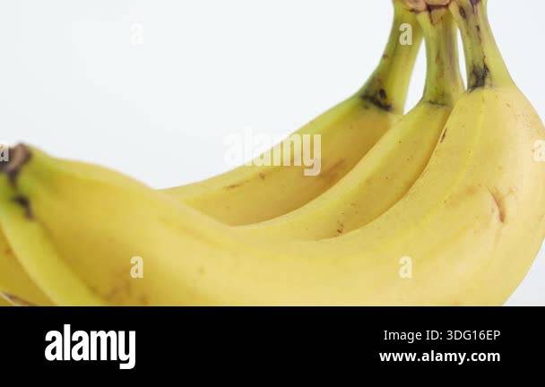 Macro-style video of ripe bananas spinning slowly in studio lighting ...