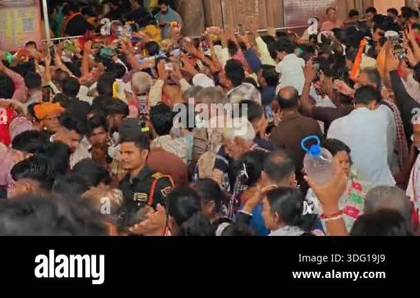 A sea of people sitting or standing inside a temple hall during a major ...
