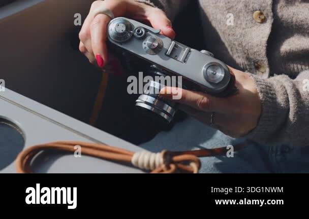 Close-up of a girl holding a film camera and about to take a picture ...