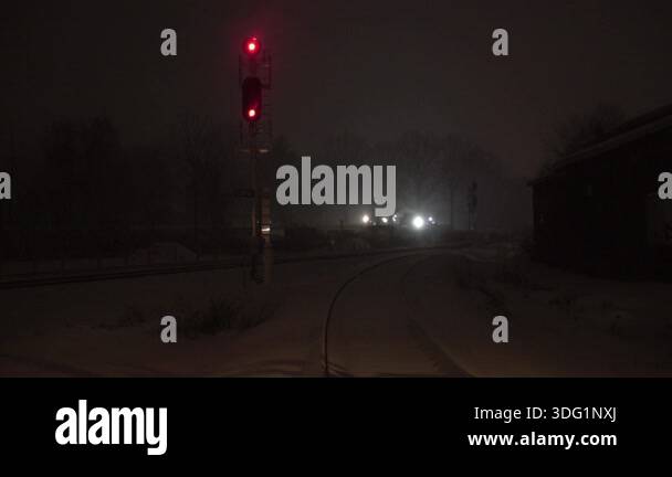 Red block signal lights on snow covered train tracks at night small ...