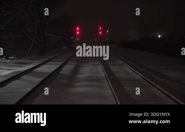 Red block signal lights on snow covered train tracks at night. 4k Stock ...