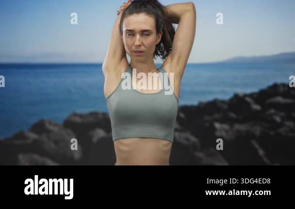Young hispanic woman stretching arms before tying hair revealing raised ...