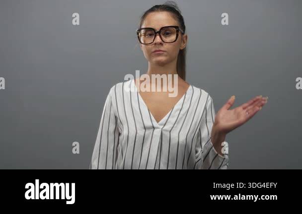 Woman wearing striped blouse and oversized glasses giving thumbs up and ...