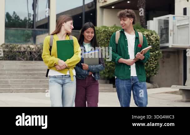 Blond university student girl walking with friends in college campus ...