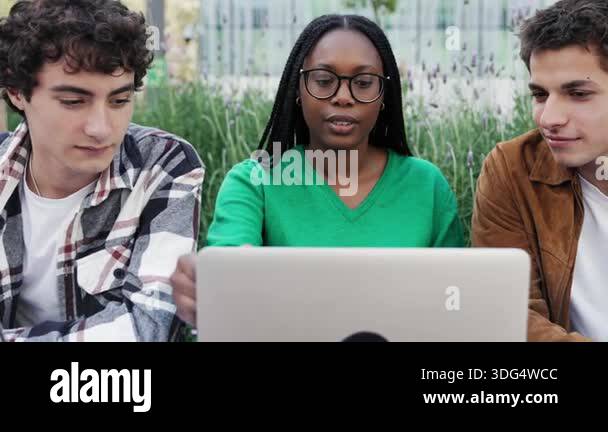 Black female student with classmates using laptop working and learning ...