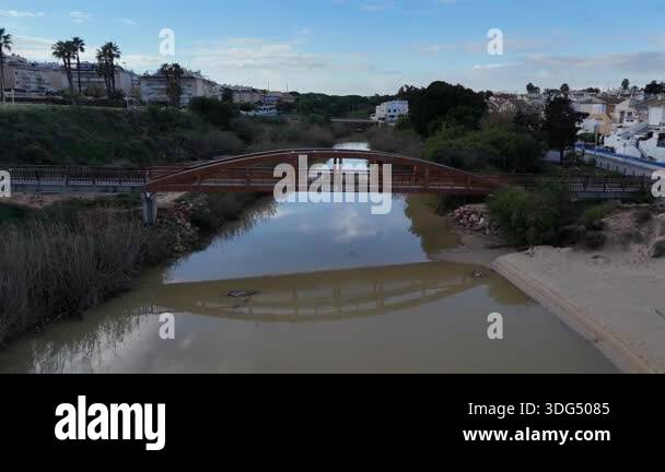Drone view of river mouth with pedestrian bridge sandy beach and calm ...