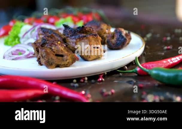 Chef slicing freshly grilled juicy beef steak meat with a knife on a ...