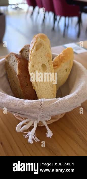 Slices of bread inside basket with utensils, glasses, and plates in ...