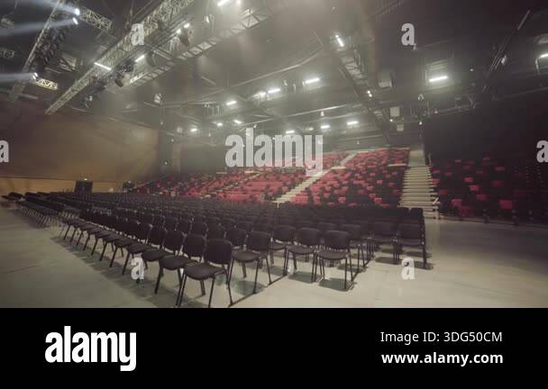 Light fills concert hall highlighting amount of red seats and stage ...