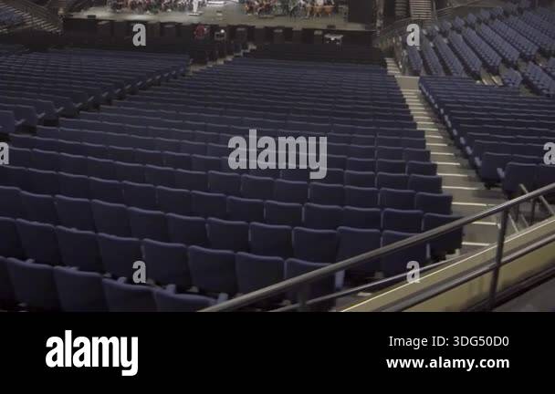 Numerous rows of dark blue chairs indicate large venue set up for ...