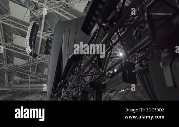 Lighting equipment hangs from overhead truss structure. Black fixtures ...