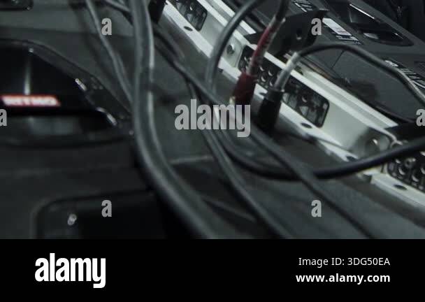 Technician plugs various cables from concert equipment on stage closeup ...