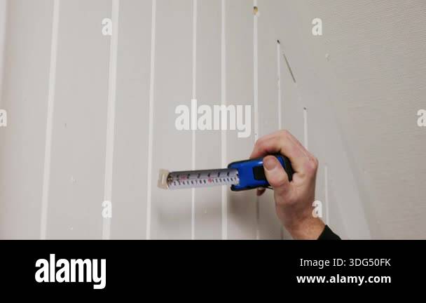 Hands measuring wall distance wit tape measure and marking position ...