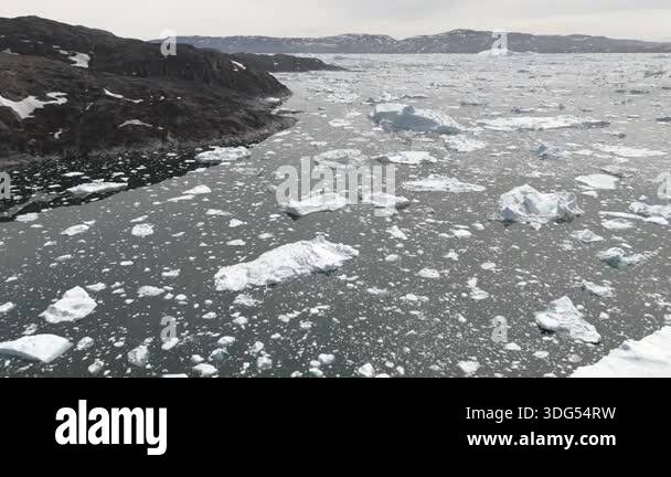 Gentle forward descent crosses tranquil polar waters scattered with ice ...