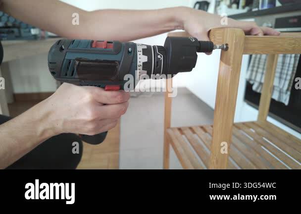 Side angle showing a cordless electric drill driver removing a screw ...