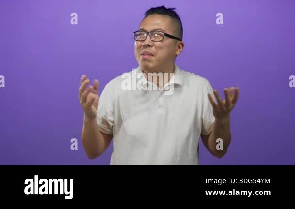 Man with open hands shrugging in studio purple backdrop and grimacing ...