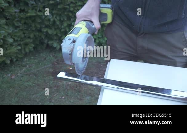 Right hand using cordless electric polisher to carve groove in aluminum ...