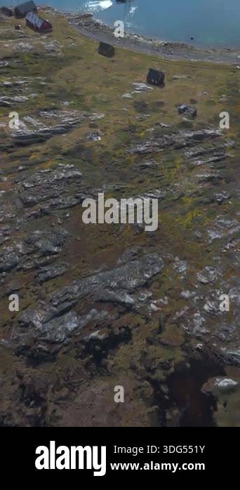 Gradual aerial lift reveals rocky terrain, abandoned coastal settlement ...