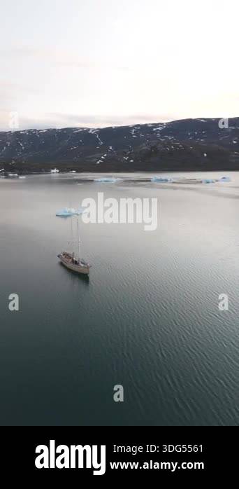 Serene aerial view shows vessel drifting on polar sea, surrounded by ...