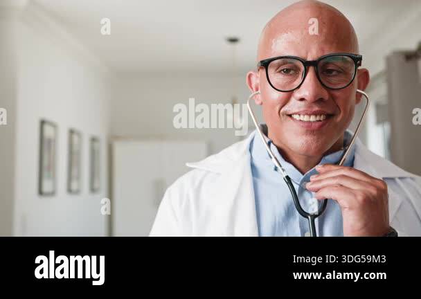 A friendly, bald doctor wearing glasses and a lab coat smiles ...